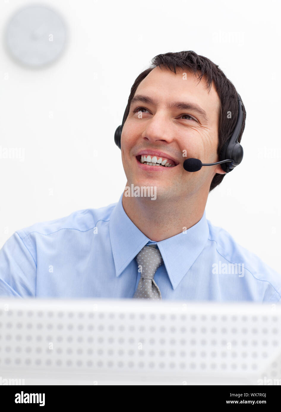 Smiling customer service agent with headset on against white background ...