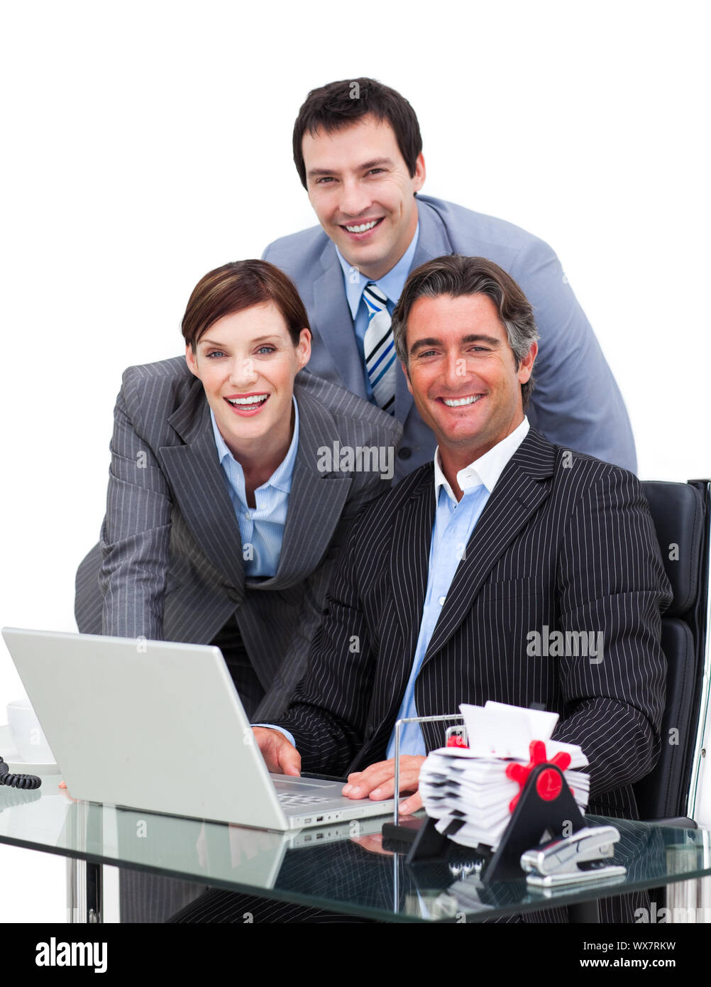 Merry business team working at a computer against a white background ...