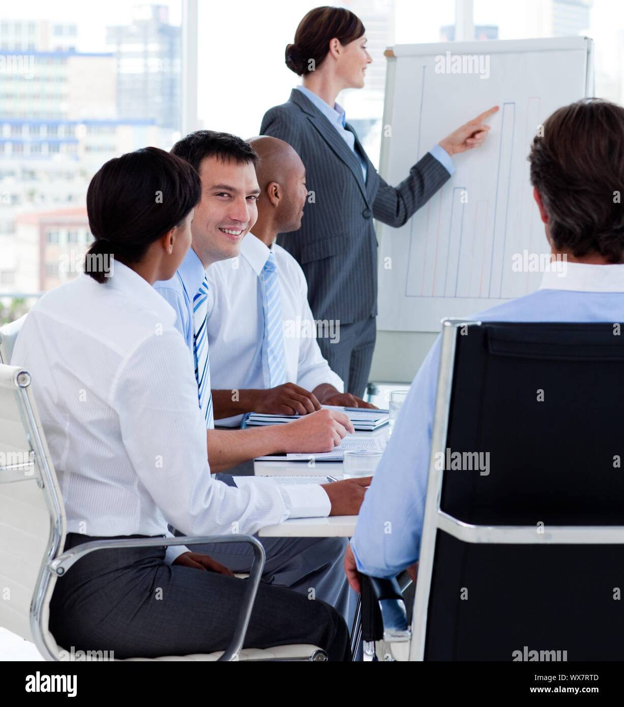 Manager reporting sales figures to her team in the office Stock Photo ...