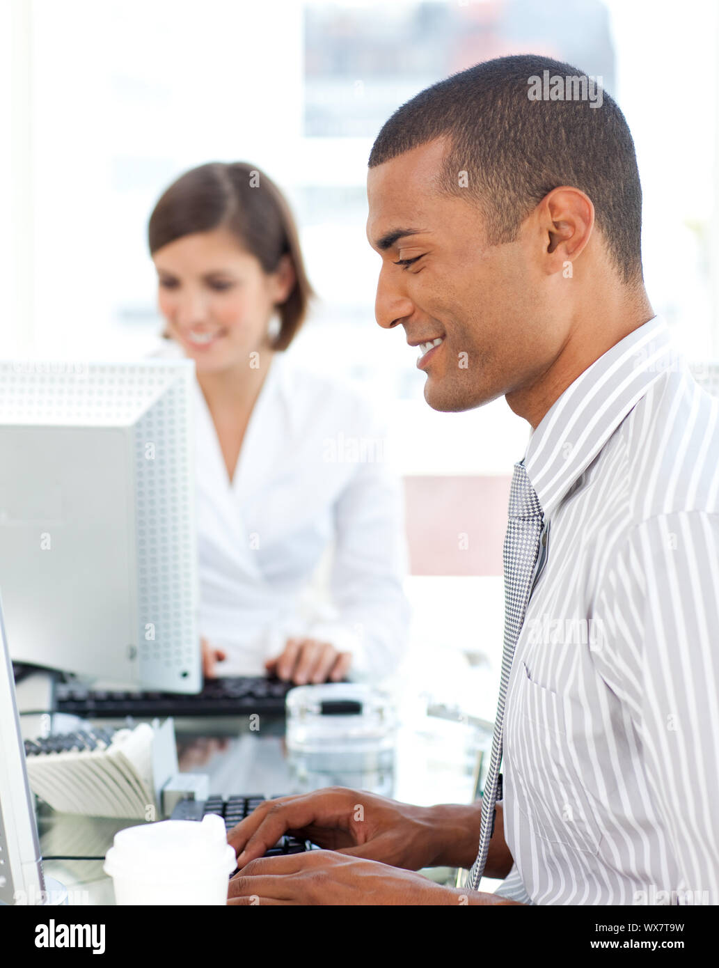 Two positive colleagues working at a their computer in the office Stock ...