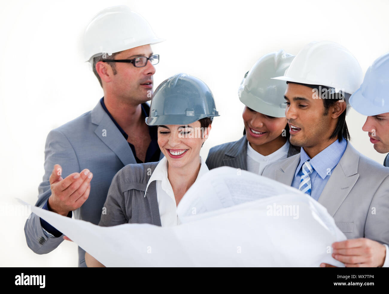 International engineers studying a construction plan against a white ...