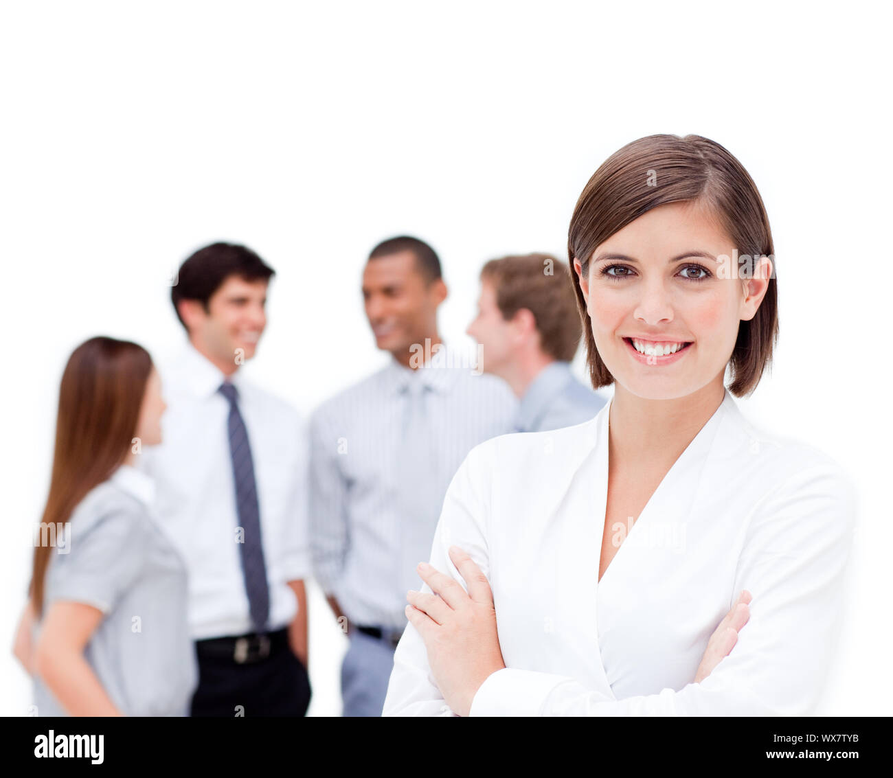 Confident manager in front of her team with folded arms against a white ...