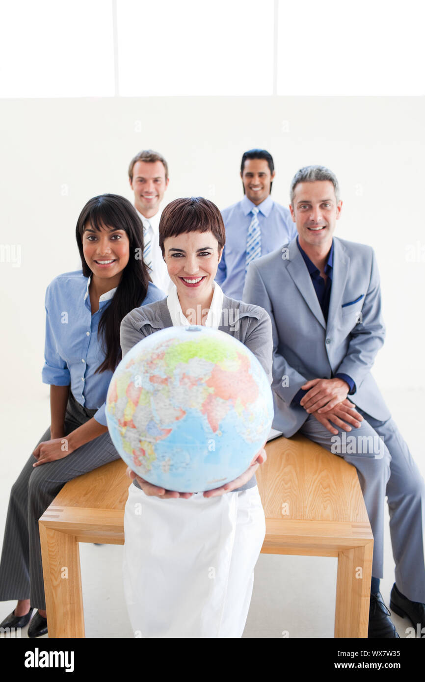 Confident business people holding a terrestrial globe in the office ...