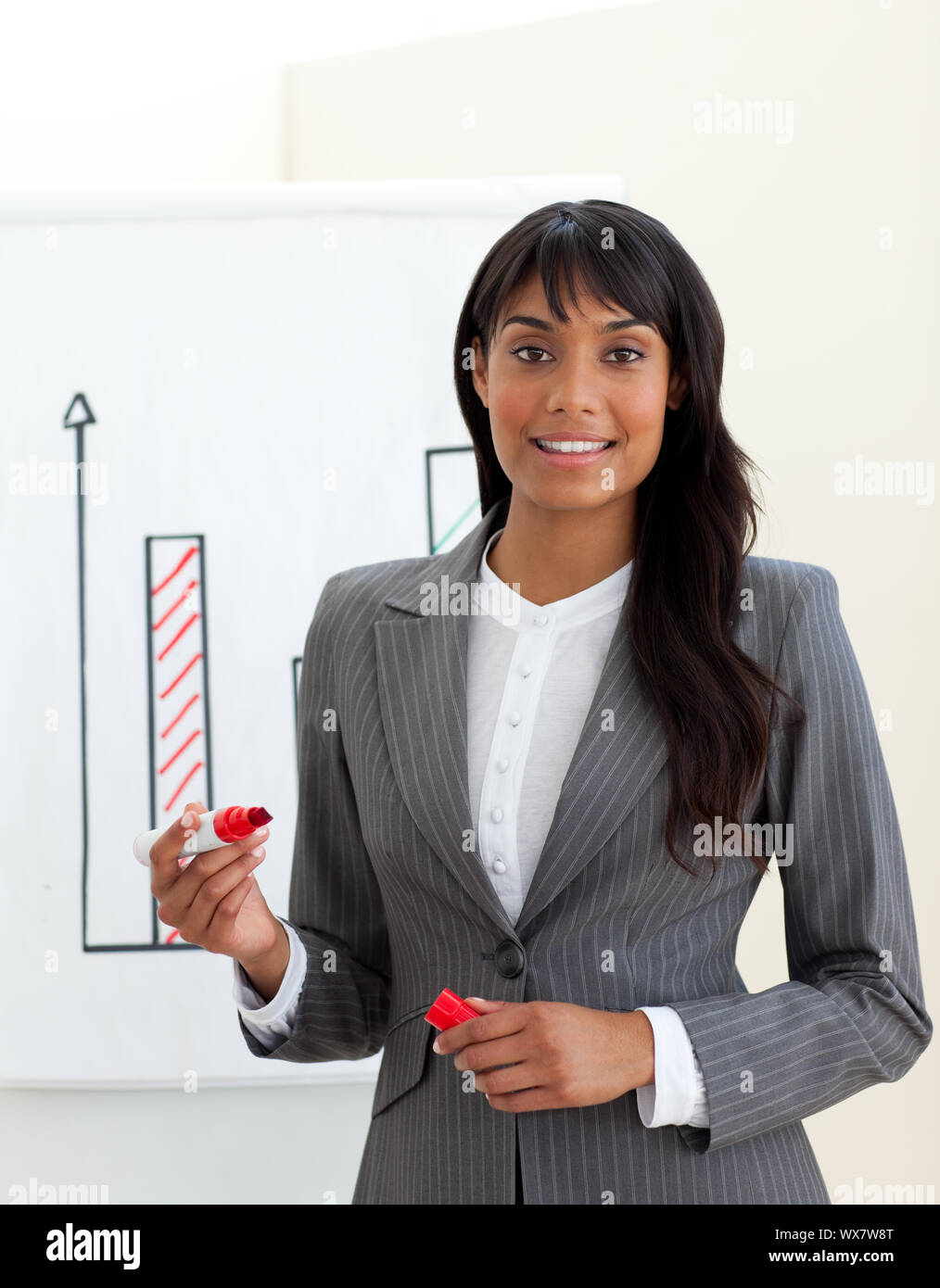 Ethnic young businesswoman reporting sales figures isolated on a white ...