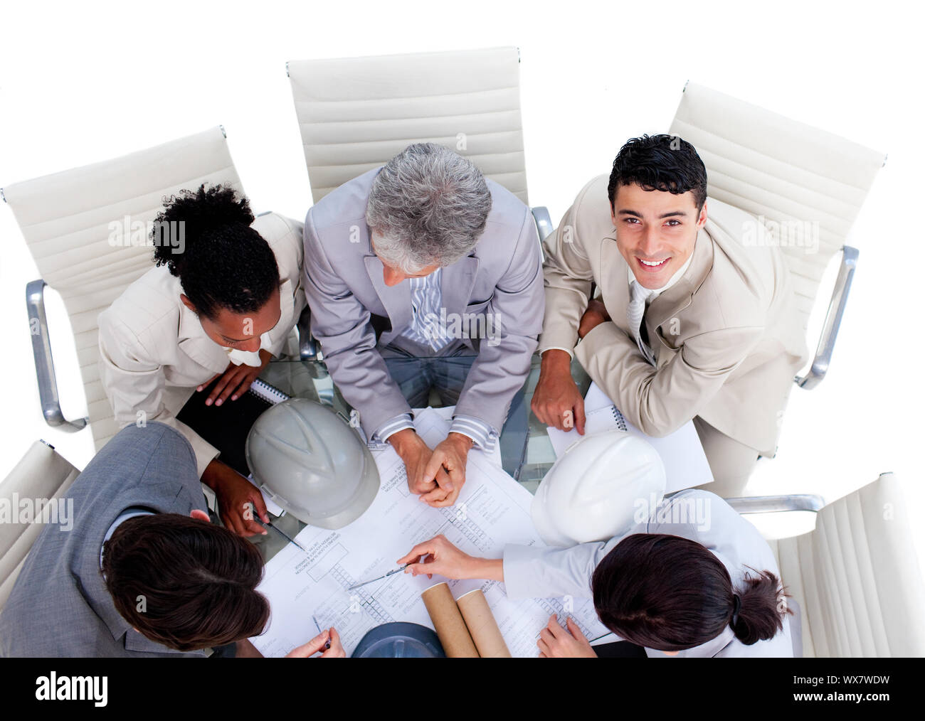 Concentrated international architects studying blueprints in a meeting ...