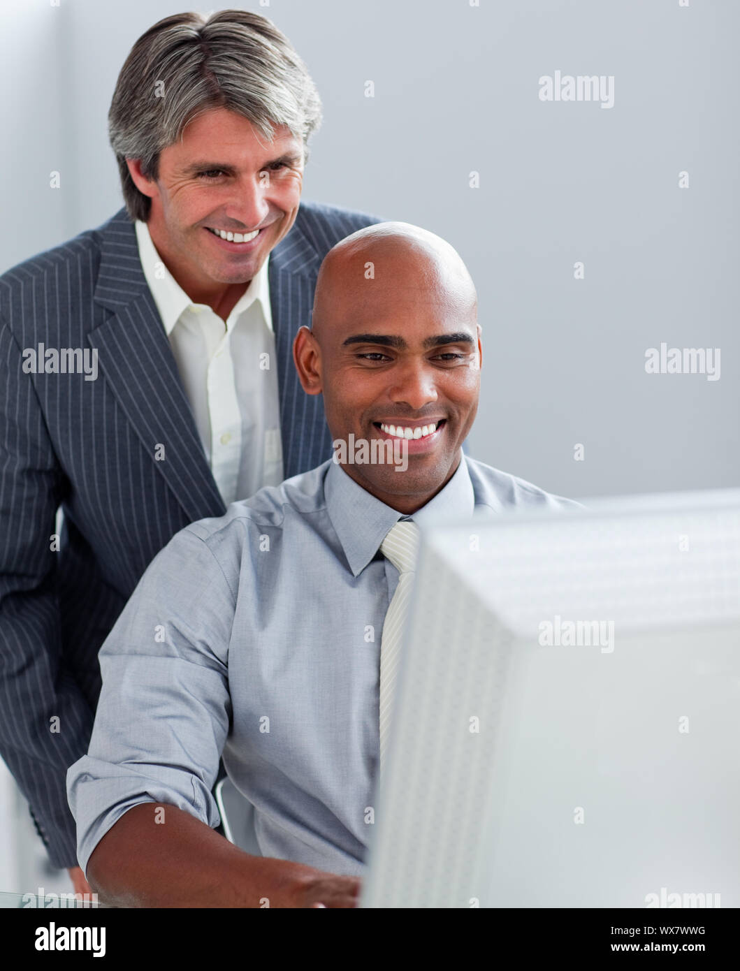 Positive business partners working at a computer together in the office ...