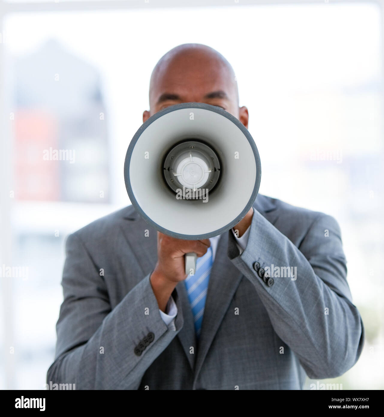 Ethnic businessman yelling through a megaphone in the office Stock ...