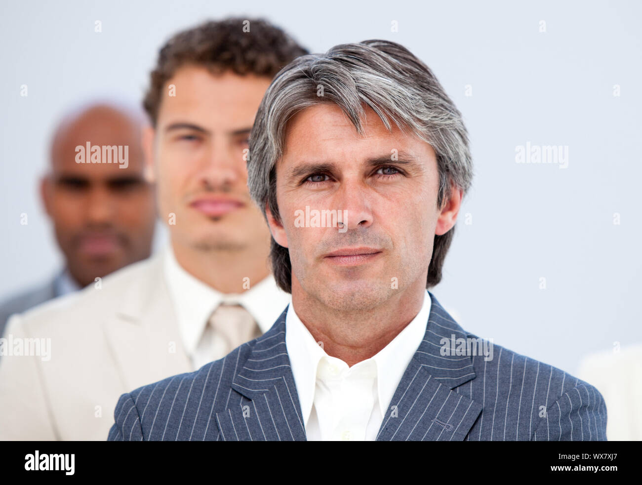 Self-assured manager and his team looking at the camera in a company ...