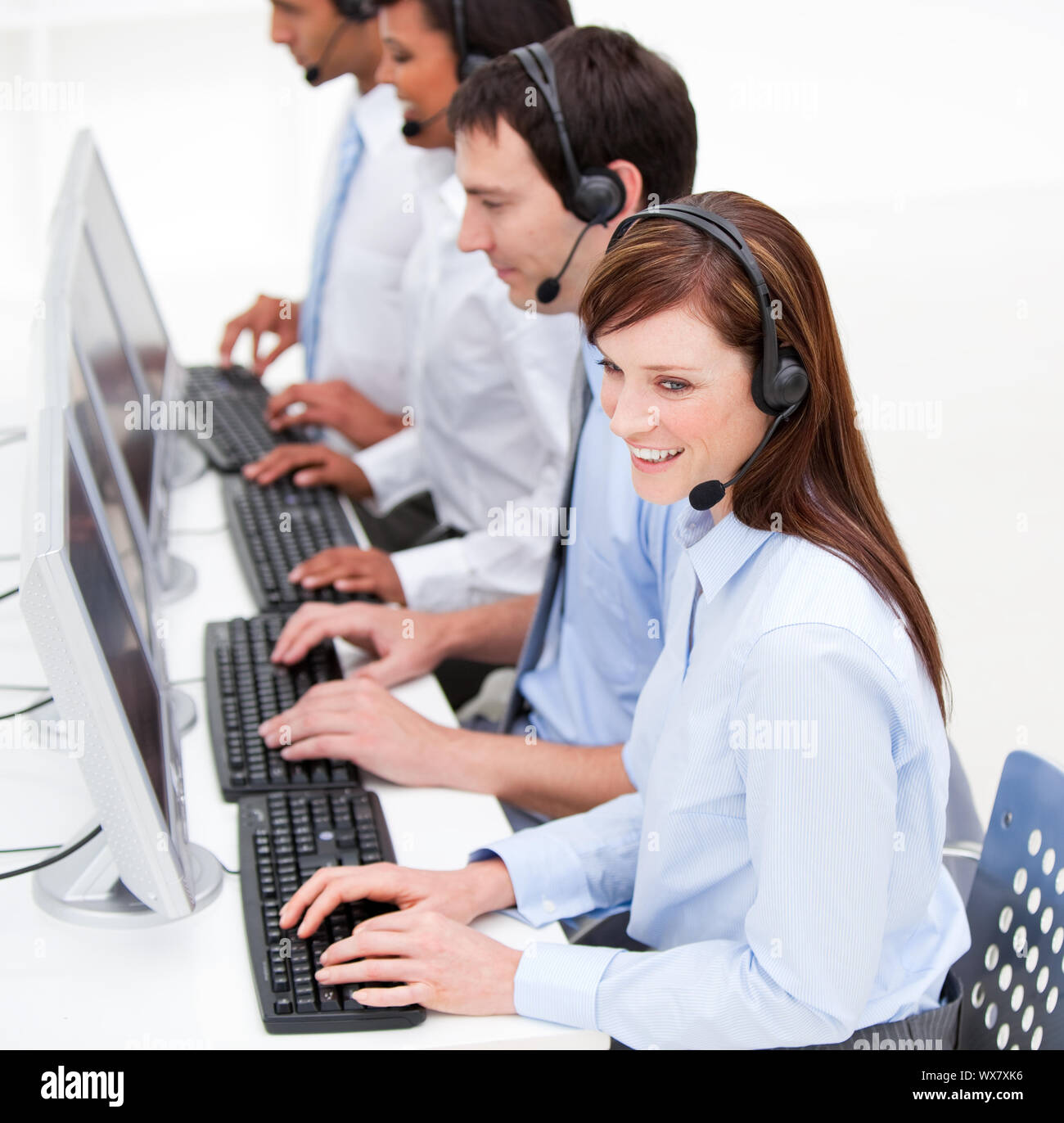 Confident customer service agents at work against a white background ...