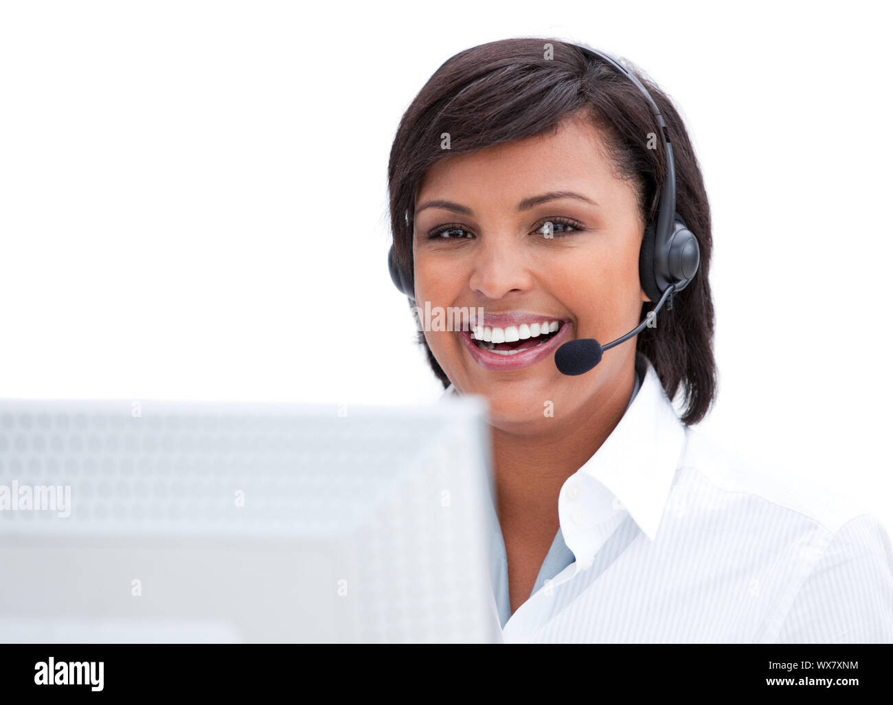 Portrait of a smiling customer service agent working at a computer ...