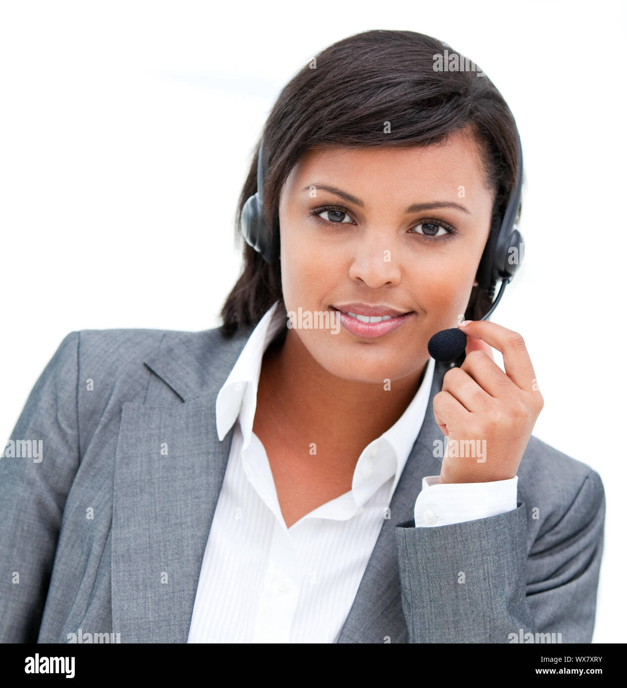 Portrait of an ethnic customer agent at work against a white background ...