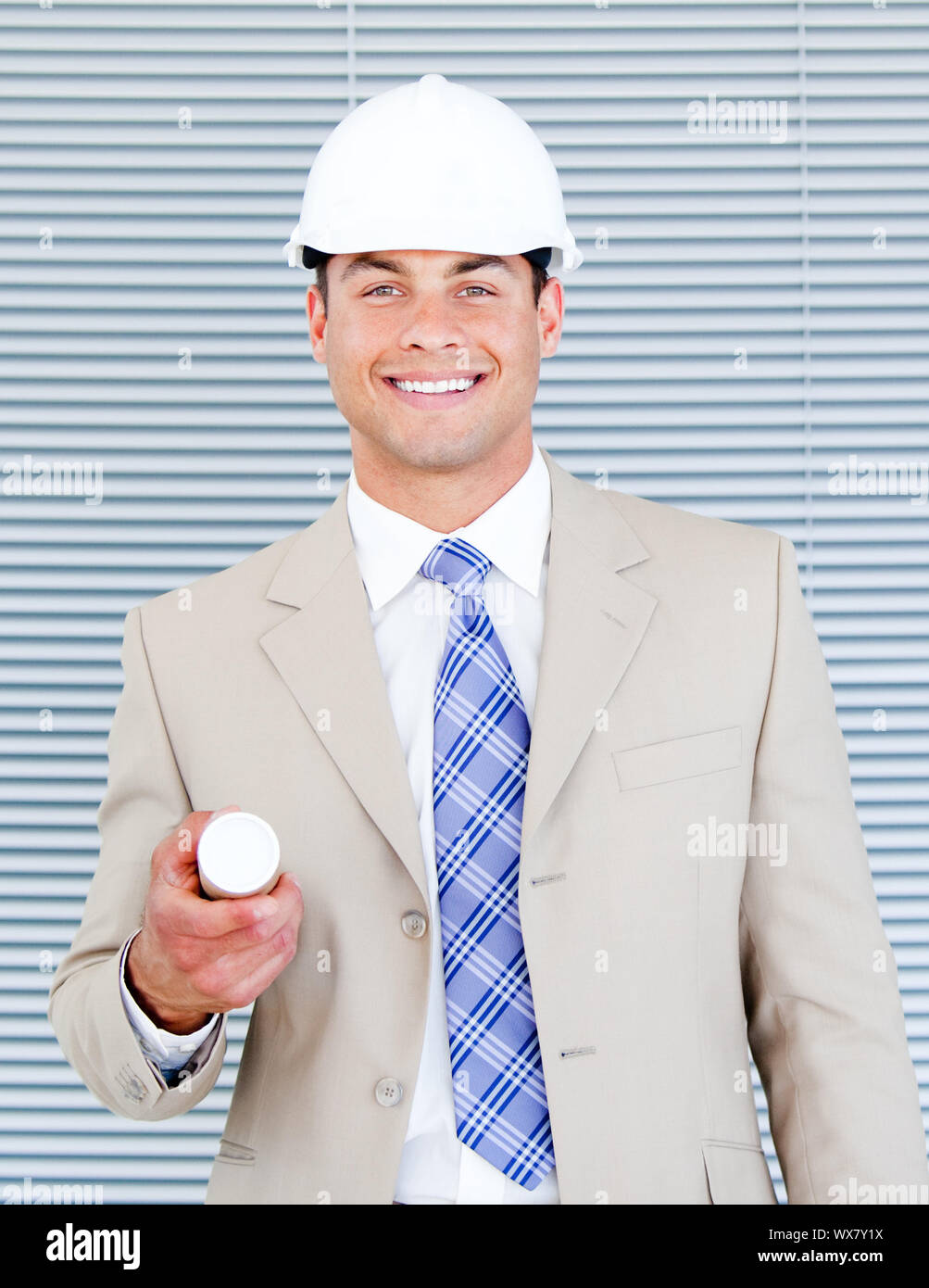 Portrait of a handsome architect holding blueprint and wearing a ...