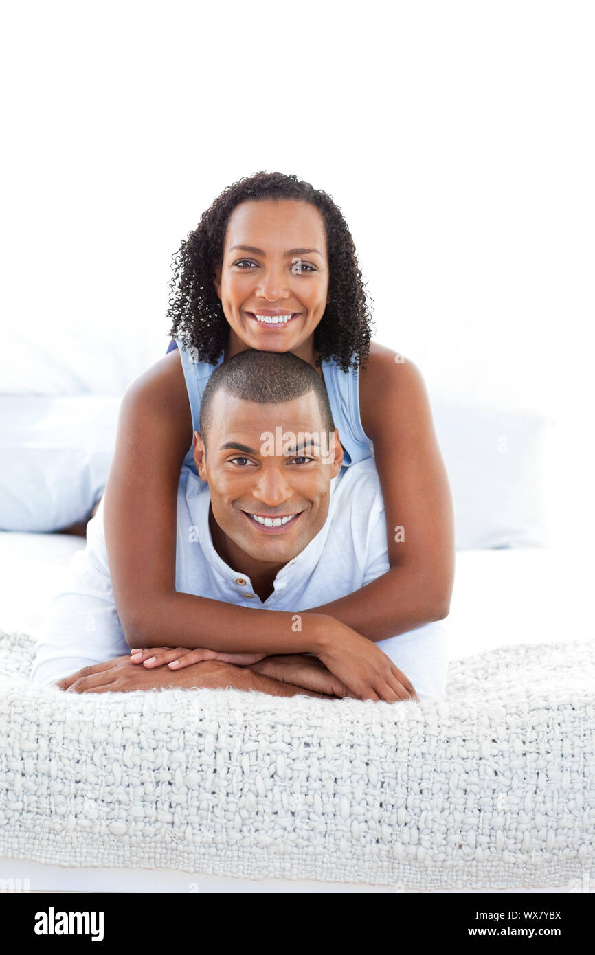 Portrait of a romantic couple cuddling lying down on bed at home Stock ...