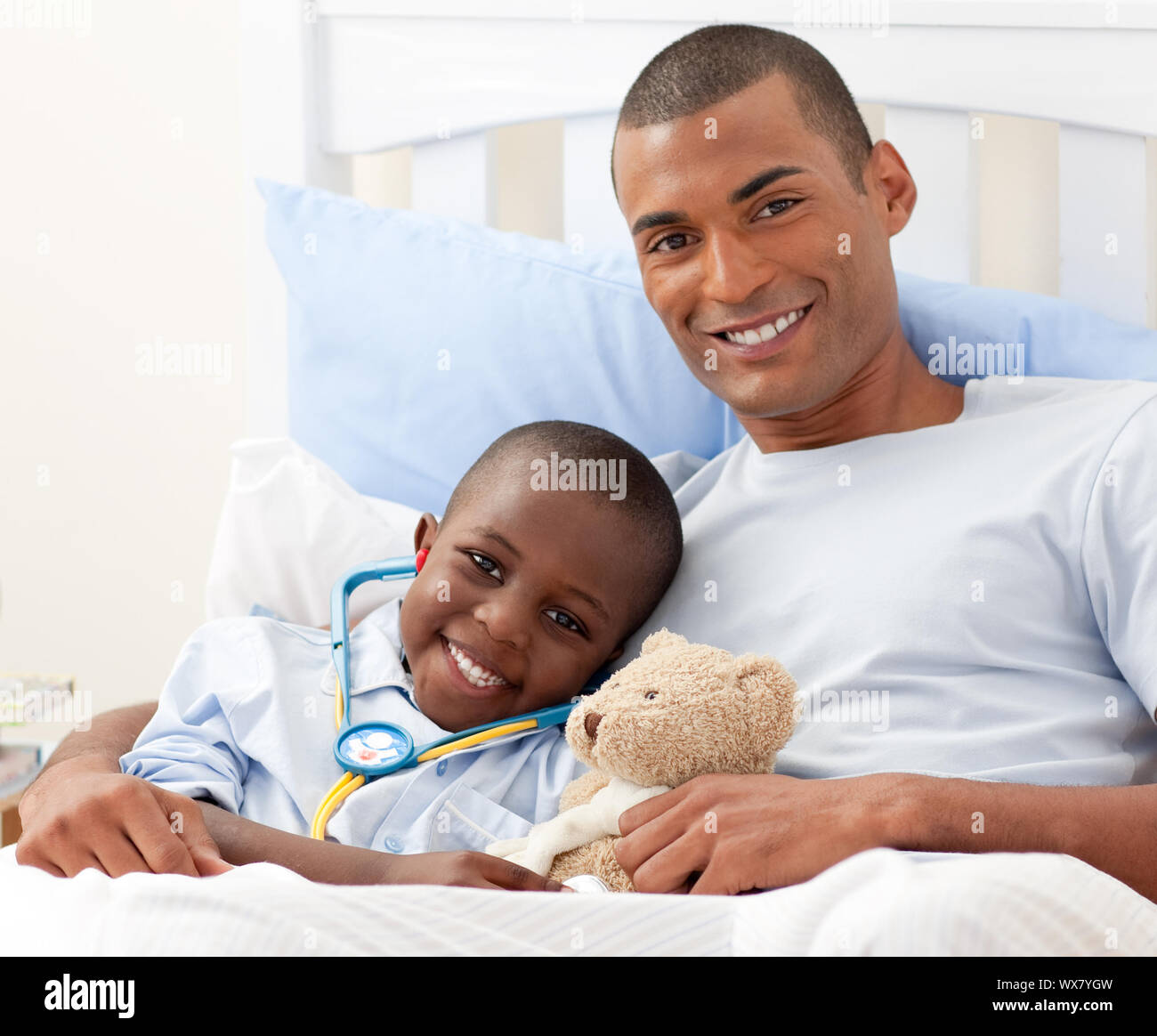 Young Father with his sick child in Bed Stock Photo - Alamy