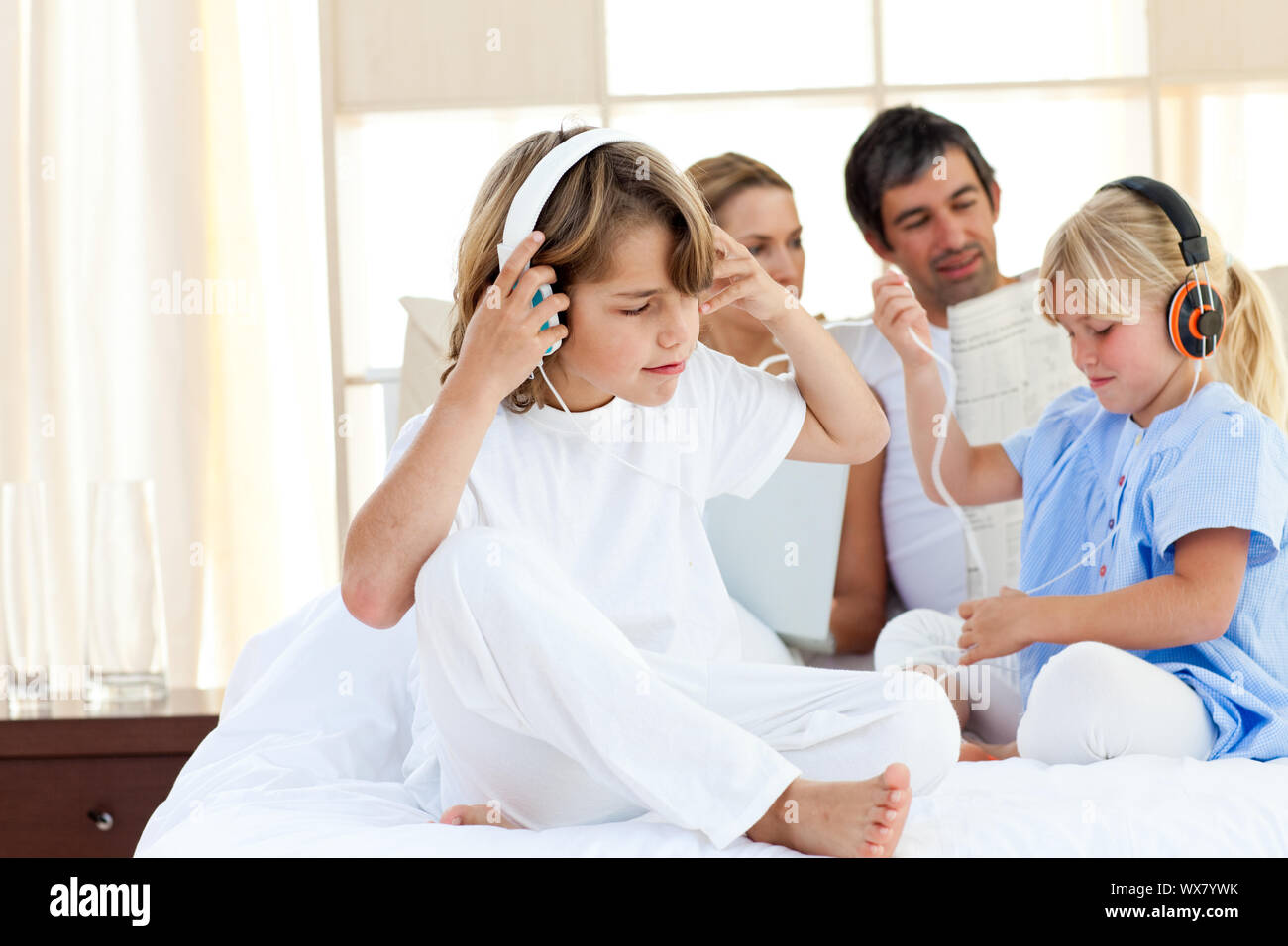 Jolly siblings listening music with headphones at home Stock Photo - Alamy