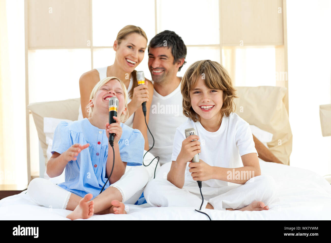 Happy family singing together through microphones Stock Photo - Alamy