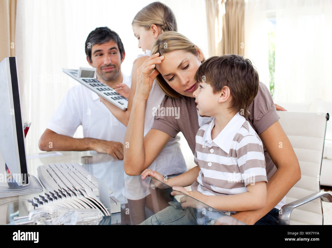 Parents helping their children do homework in the living-room Stock ...