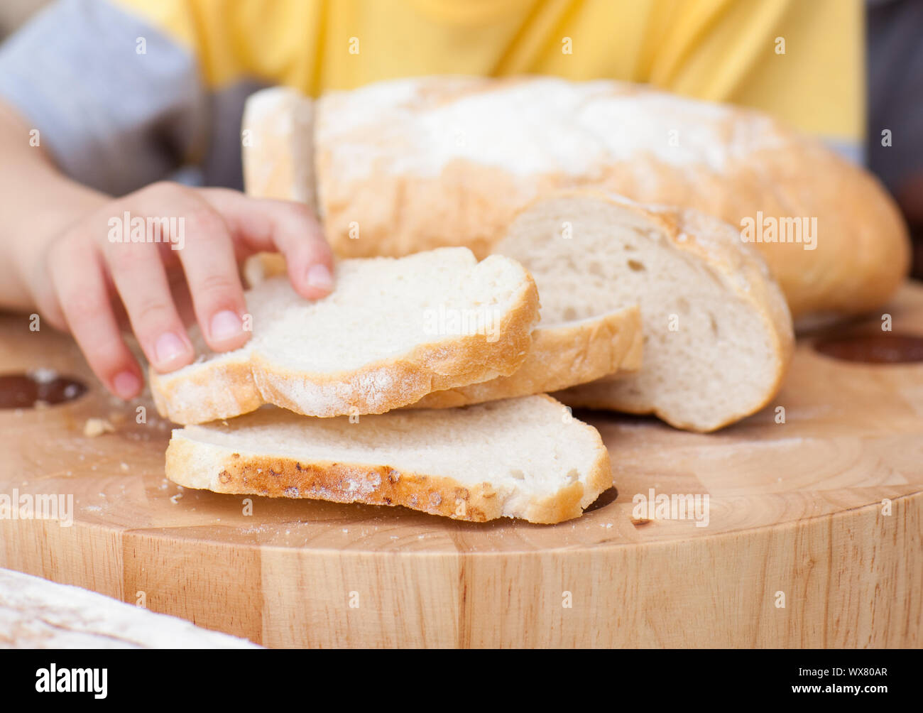 Close-up of child taking some bread in the kitchen Stock Photo - Alamy