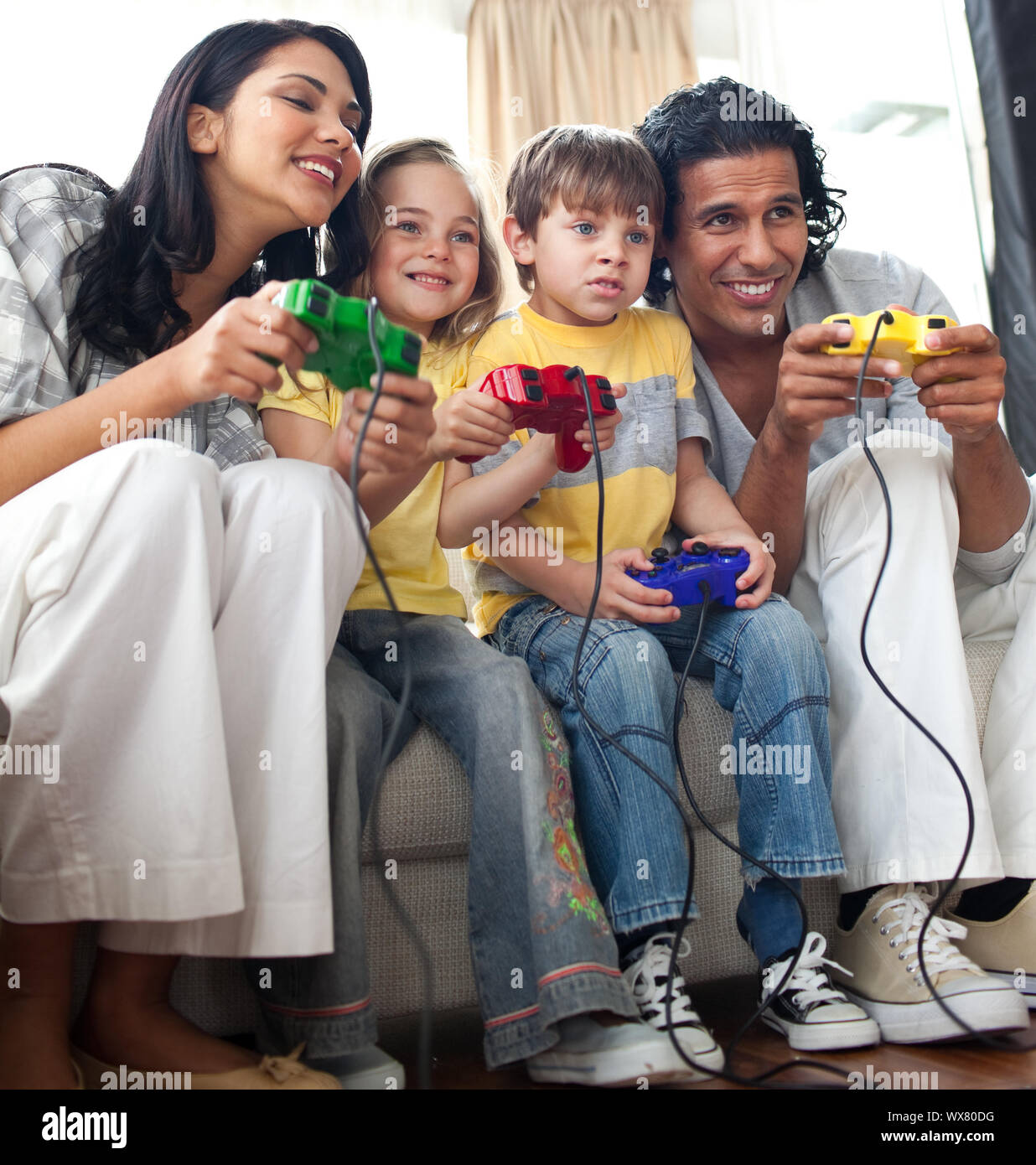 Lively family playing video game in the living room Stock Photo - Alamy
