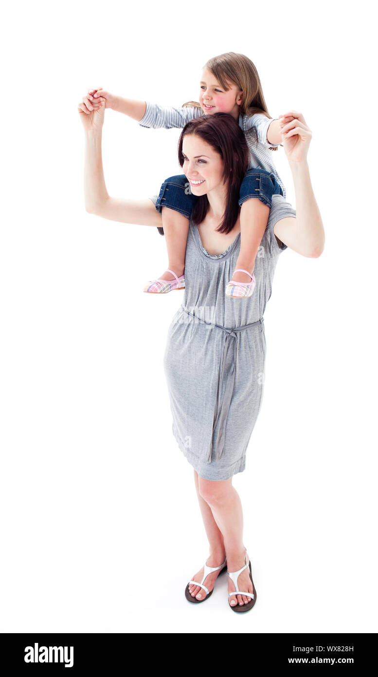 Positive mother giving her daughter piggyback ride against a white ...