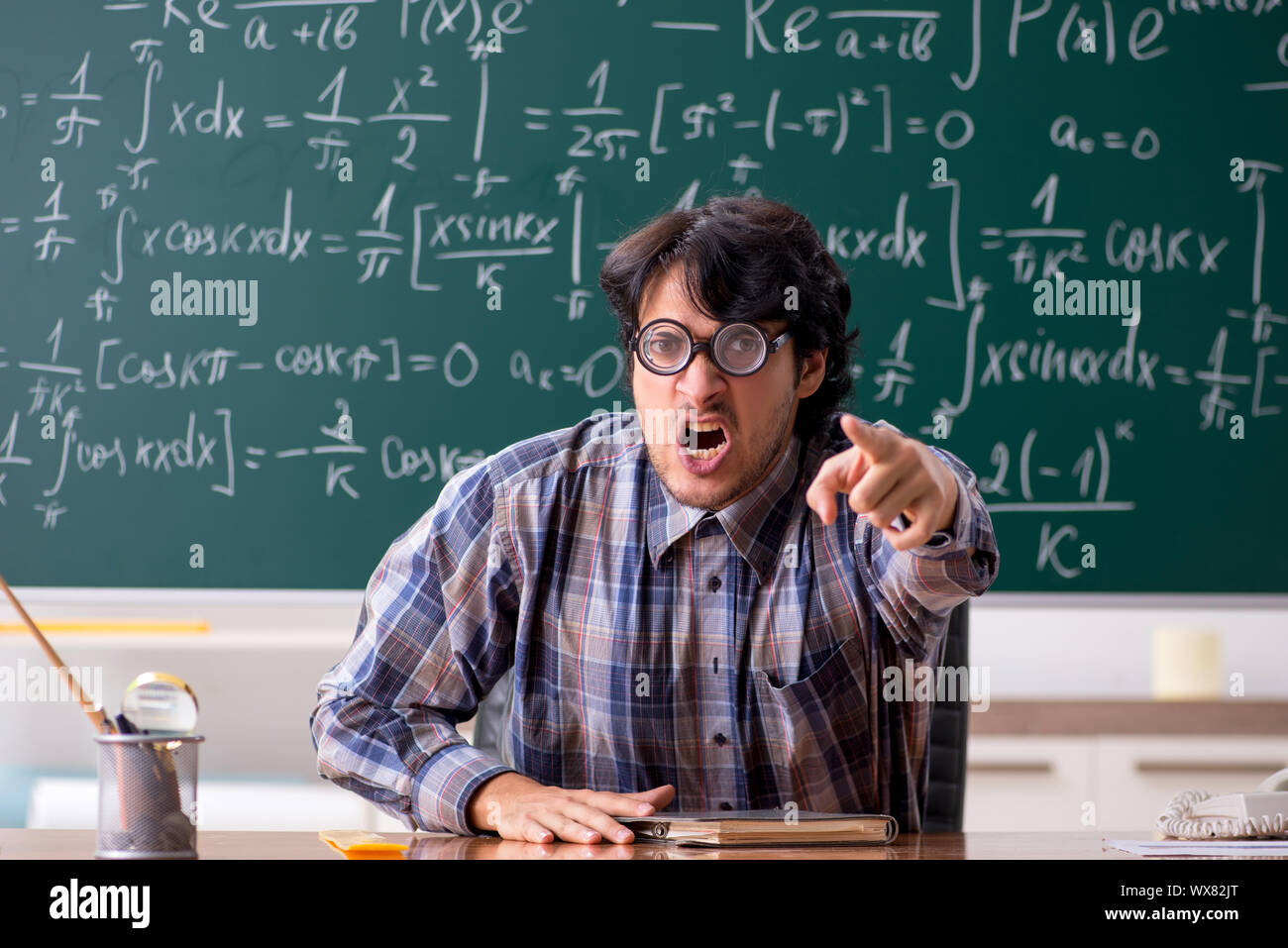 Funny male math teacher in the classroom Stock Photo - Alamy