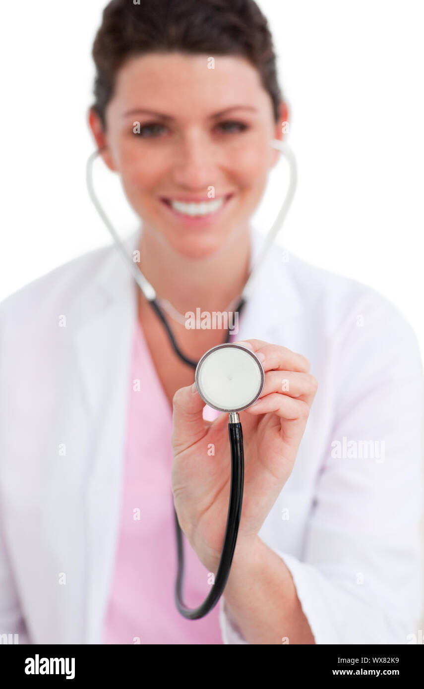 Brunette nurse holding a stethoscope against a white background Stock ...