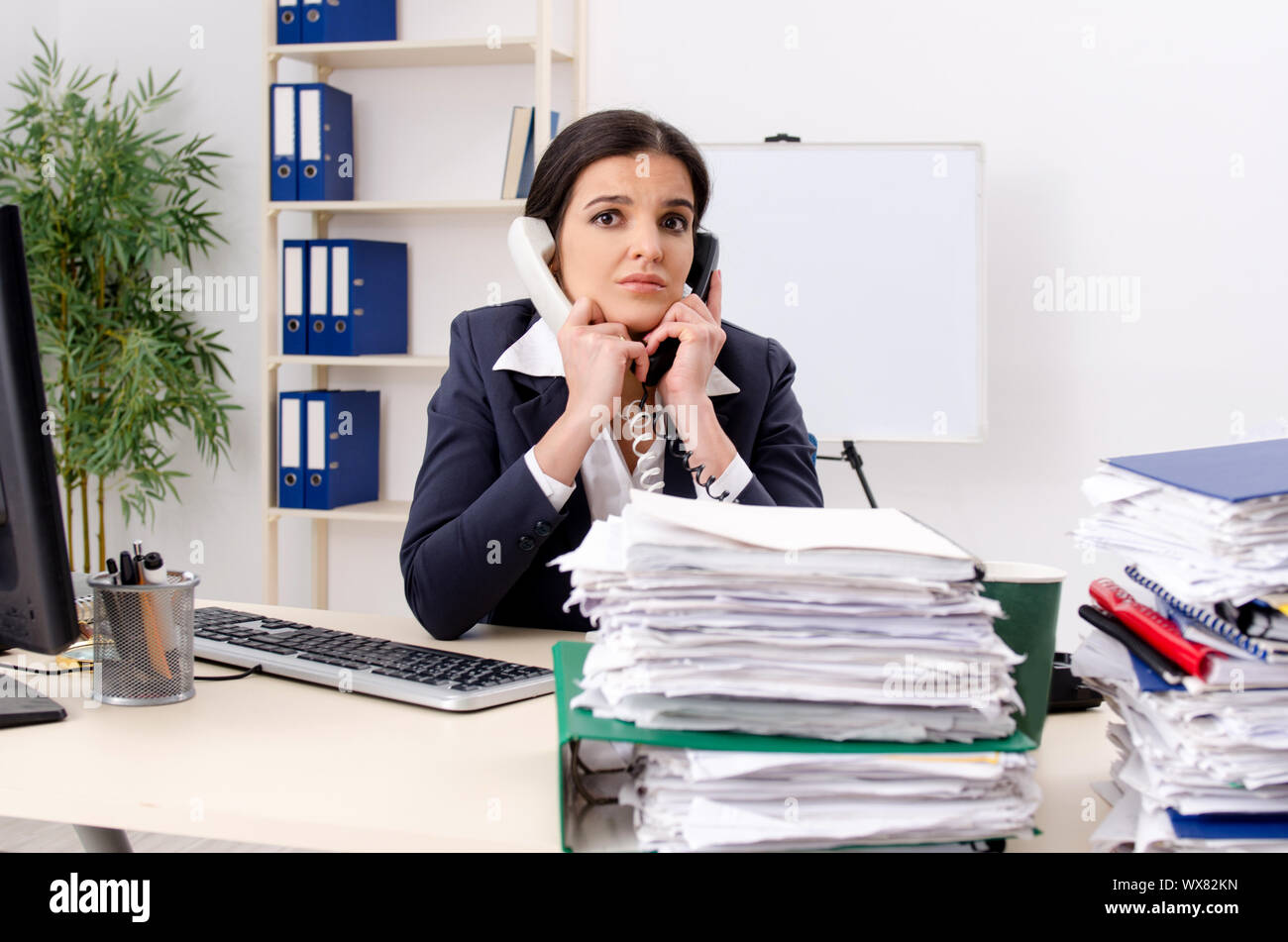 Female employee with too much work in the office Stock Photo - Alamy