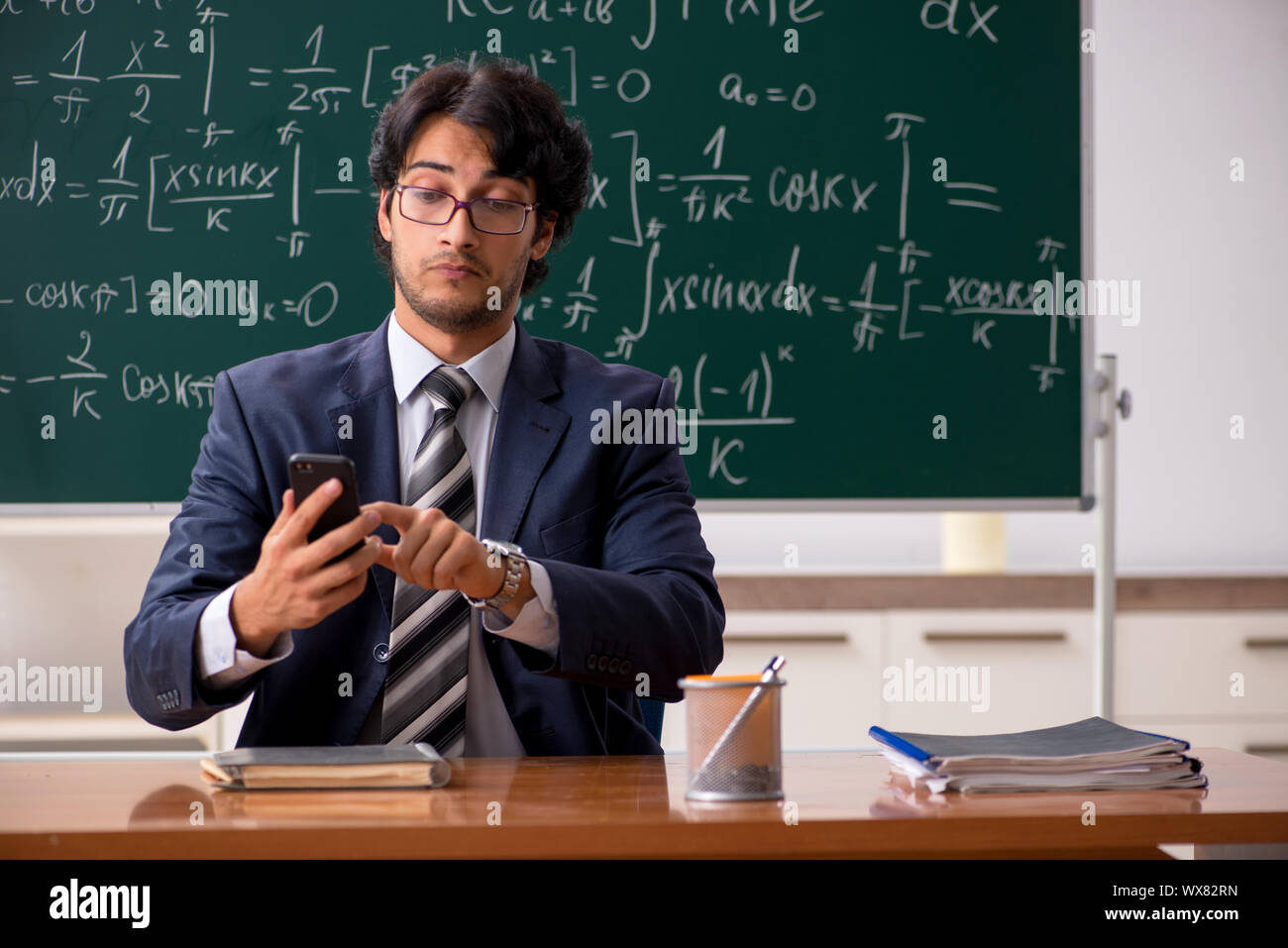 Young male math teacher in classroom Stock Photo - Alamy
