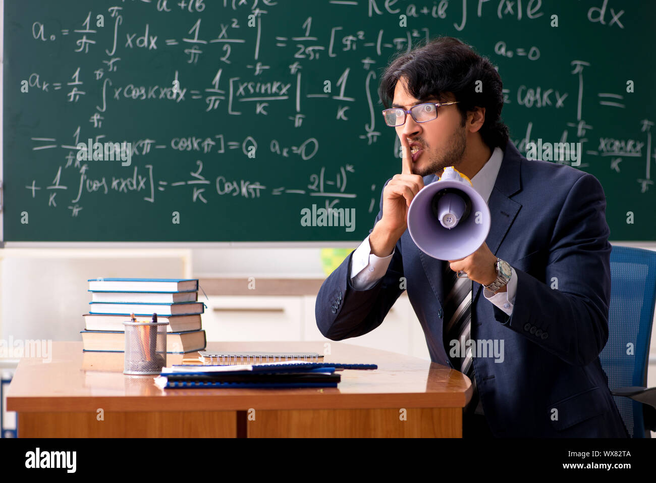 Young male math teacher in classroom Stock Photo - Alamy