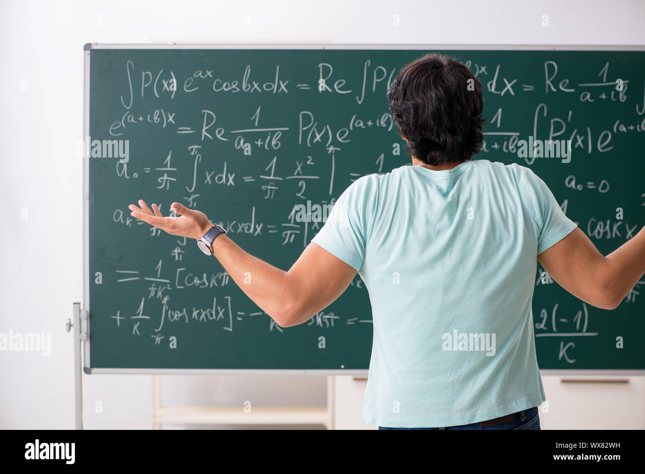 Young male student mathematician in front of chalkboard Stock Photo - Alamy