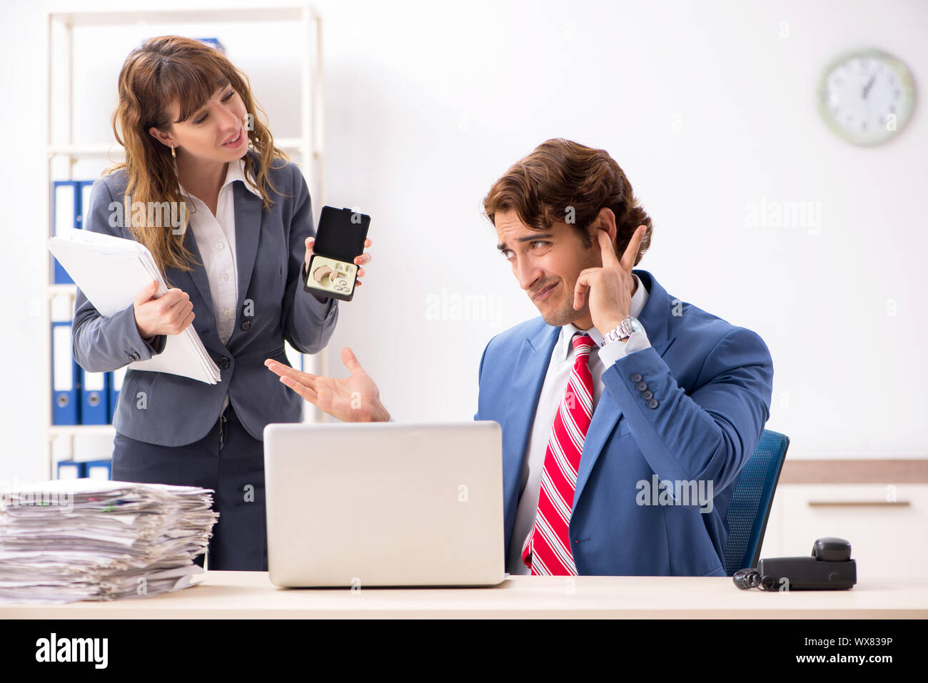 Deaf employee using hearing aid talking to boss Stock Photo - Alamy