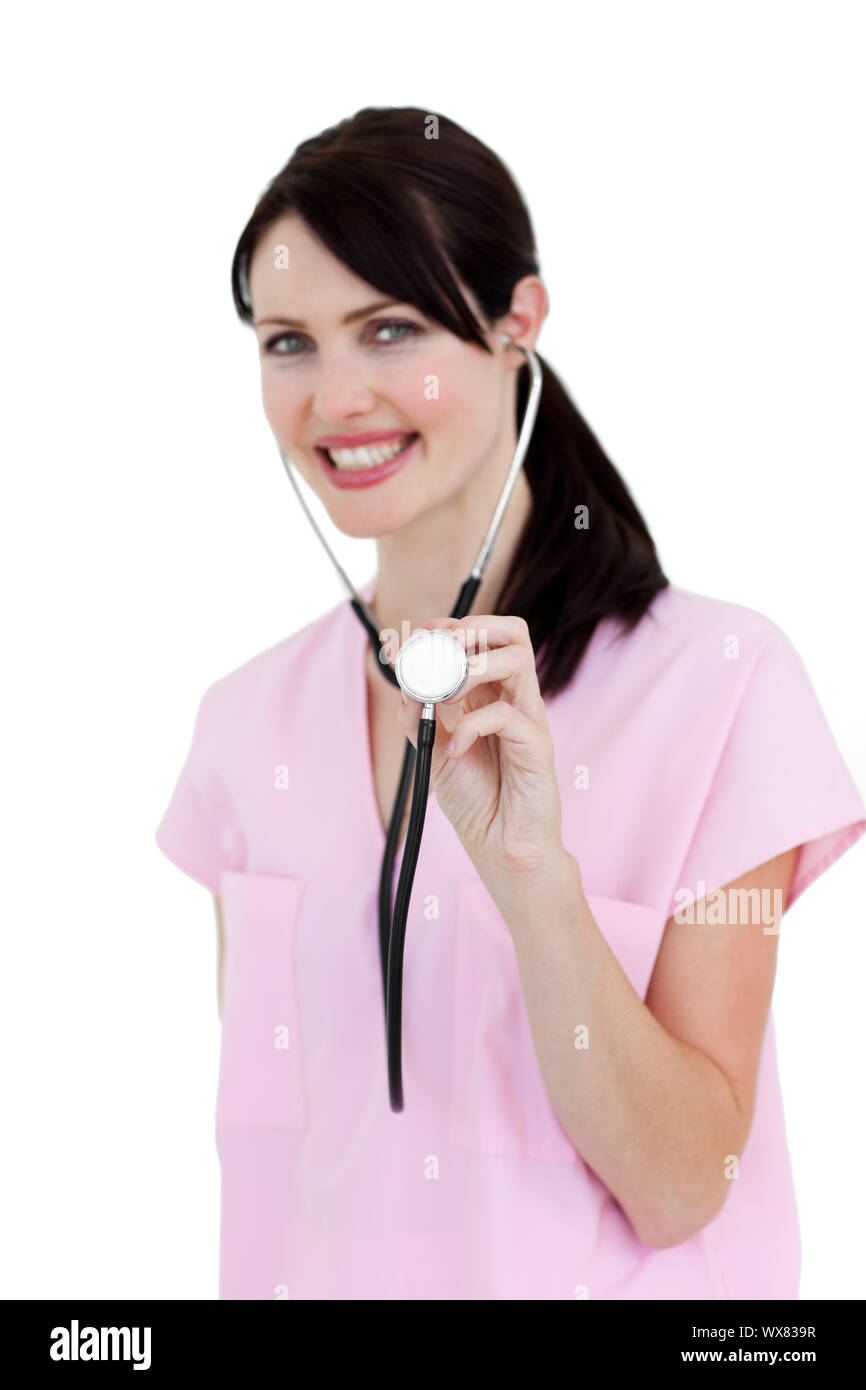 Radiant nurse showing a stethoscope against a white background Stock ...