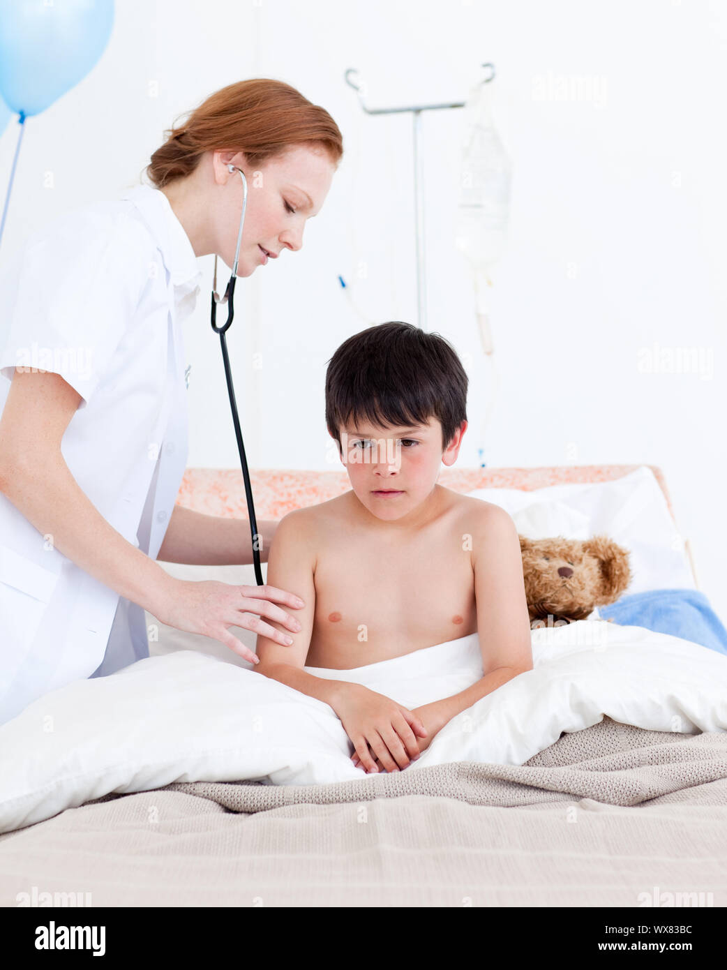 Beautiful doctor examining a little boy at the hospital Stock Photo - Alamy