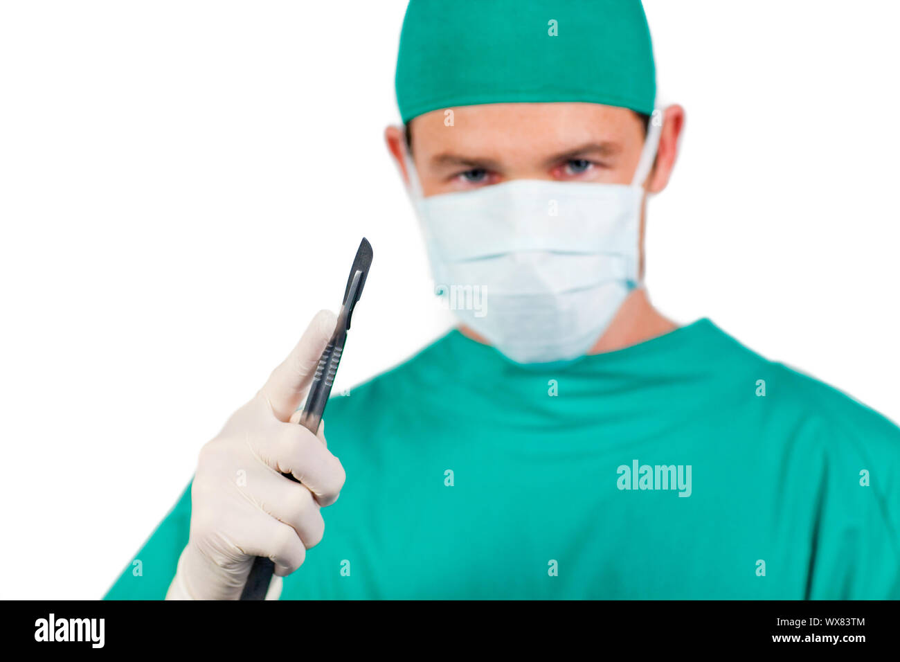 Concentrated surgeon holding a scalpel isolated on a white background ...