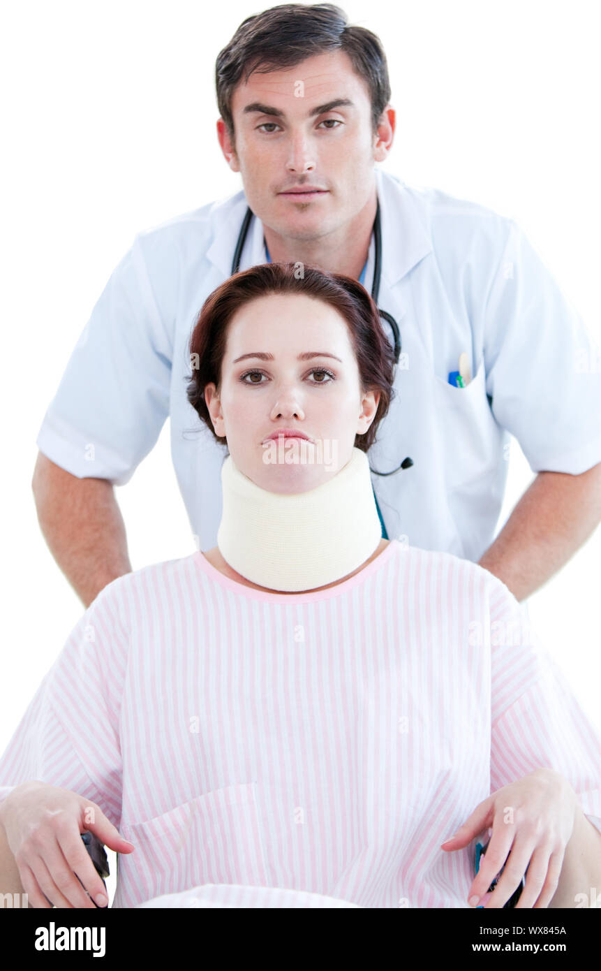 Confident male doctor carrying a patient in a wheelchair against a ...