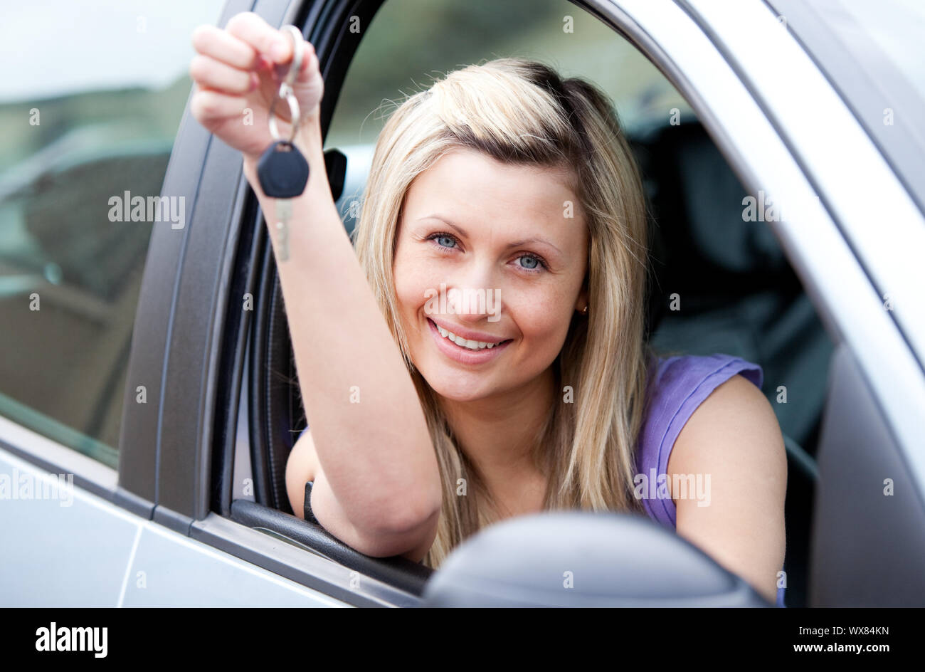 Portrait of an attractive young driver holding a key after bying a new ...