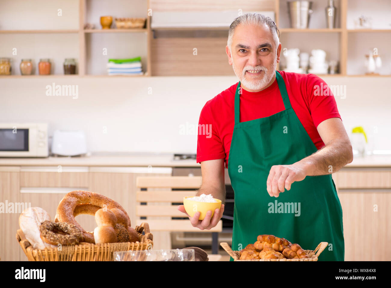 Old male baker working in the kitchen Stock Photo - Alamy