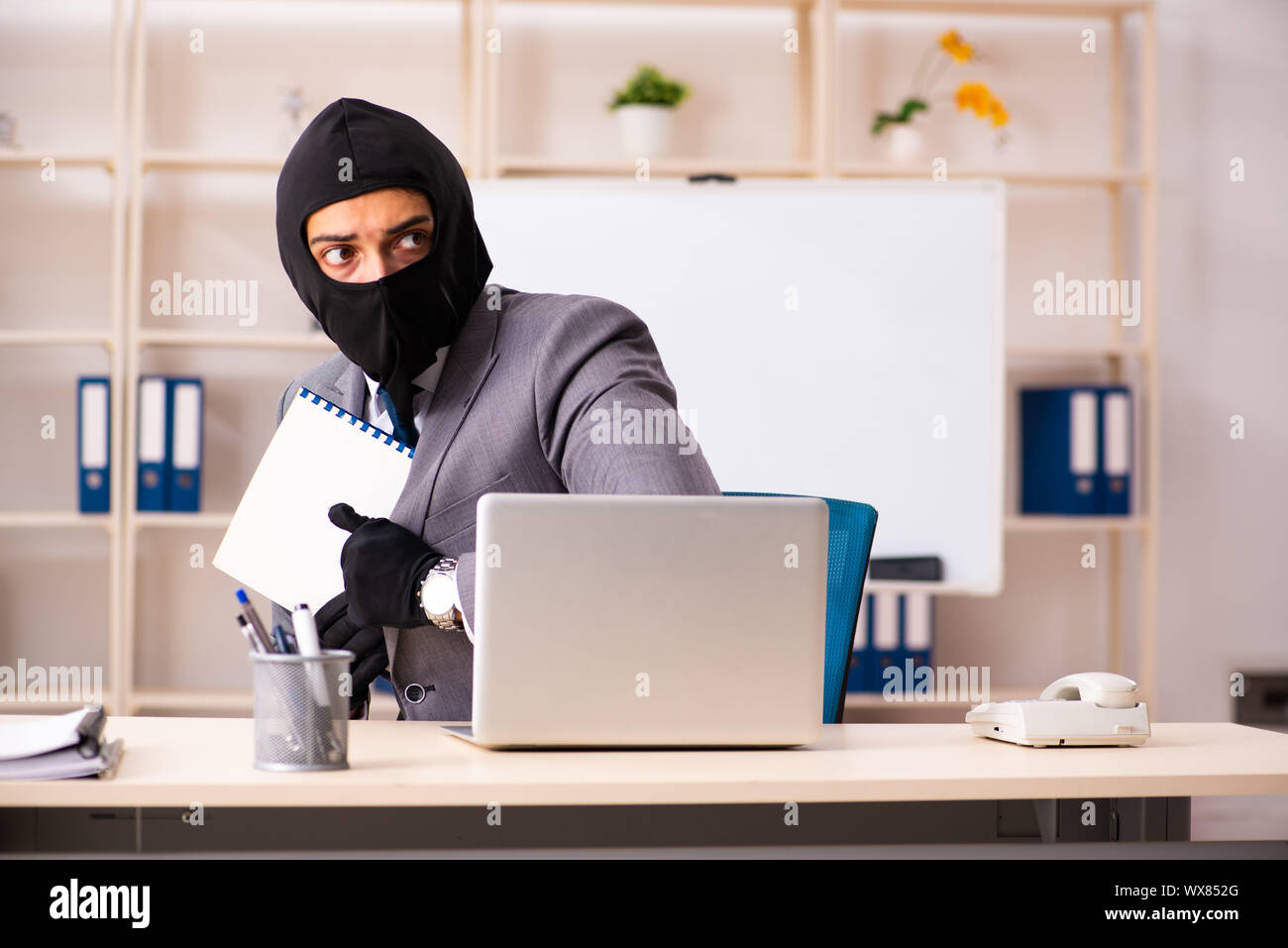 Male gangster stealing information from the office Stock Photo - Alamy