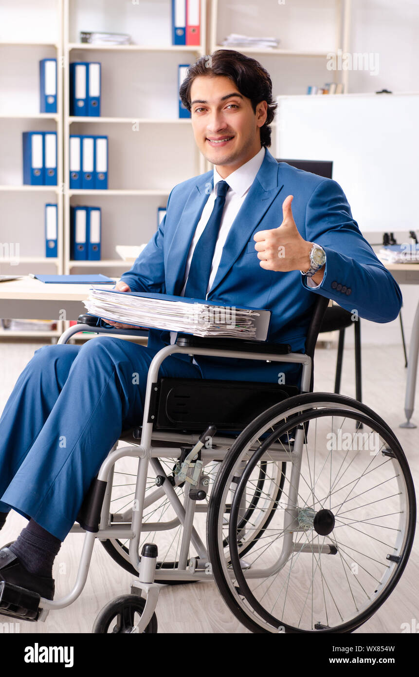 Male employee in wheelchair working at the office Stock Photo - Alamy