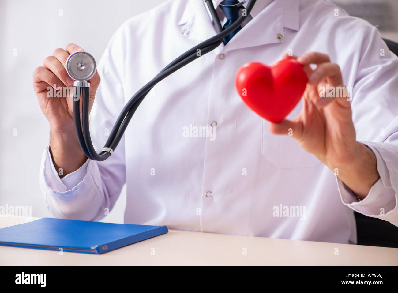 Male doctor cardiologist holding heart model Stock Photo - Alamy