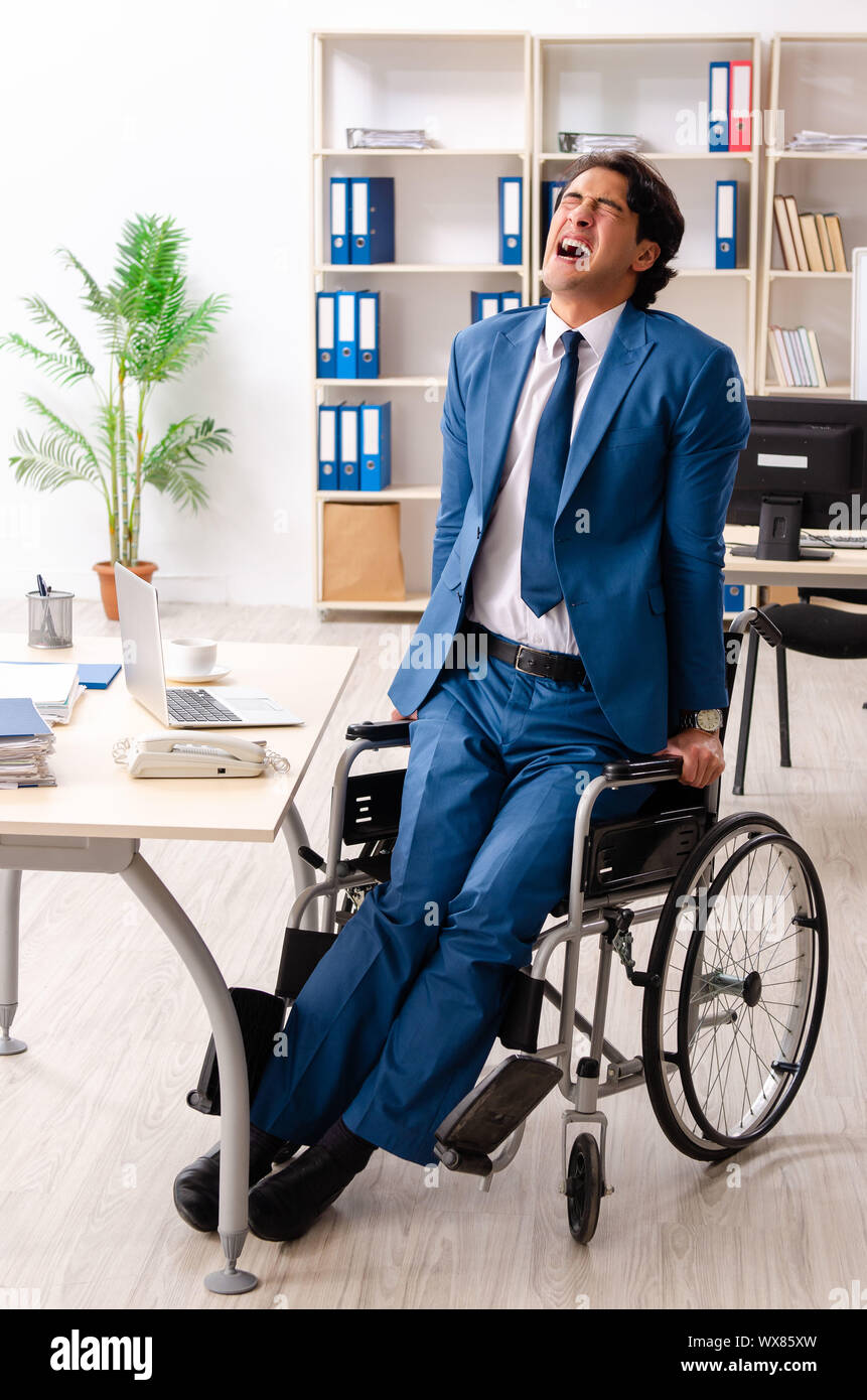 Male employee in wheelchair working at the office Stock Photo - Alamy