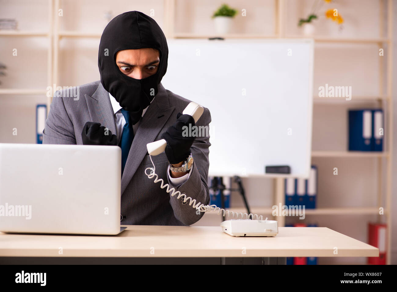 Male gangster stealing information from the office Stock Photo - Alamy