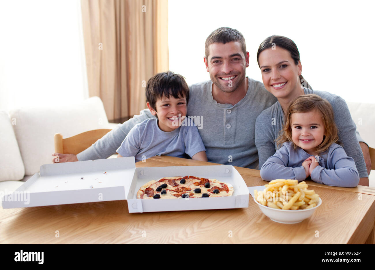 Happy family eating pizza and fries at home Stock Photo - Alamy