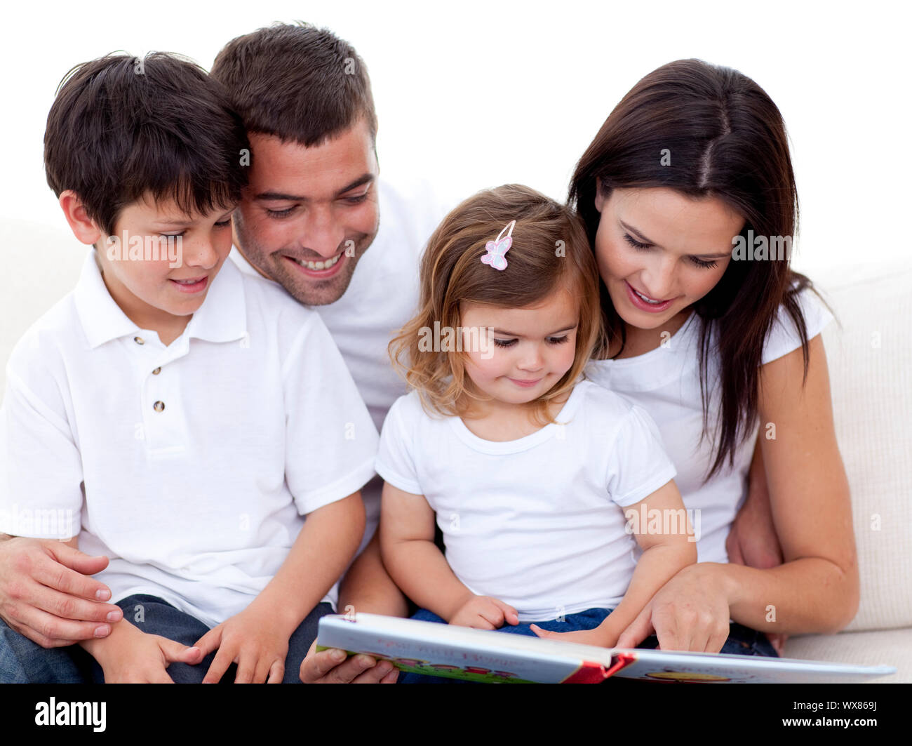 Portrait of a lovely family reading a book Stock Photo - Alamy