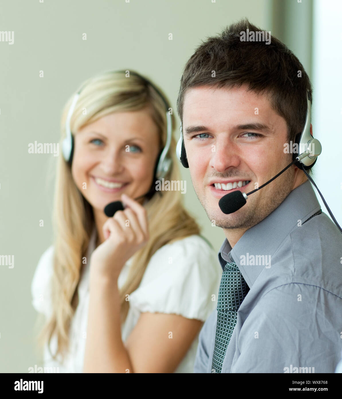 Young people with headsets at work Stock Photo - Alamy