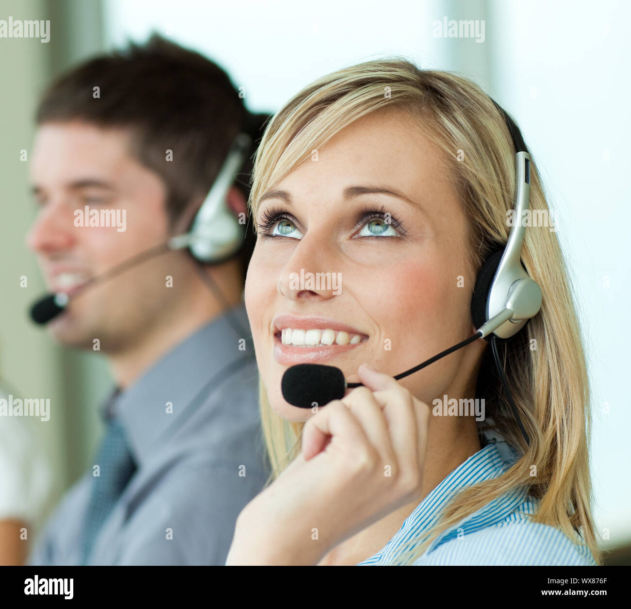 Two business people with headsets in an office Stock Photo - Alamy