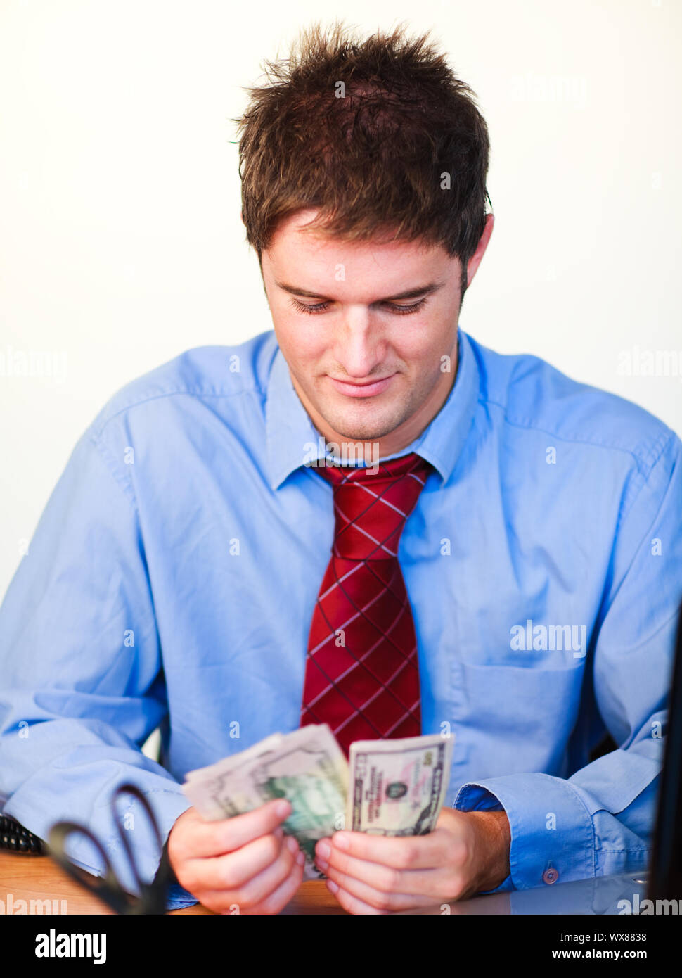 Young businessman counting money at office Stock Photo - Alamy