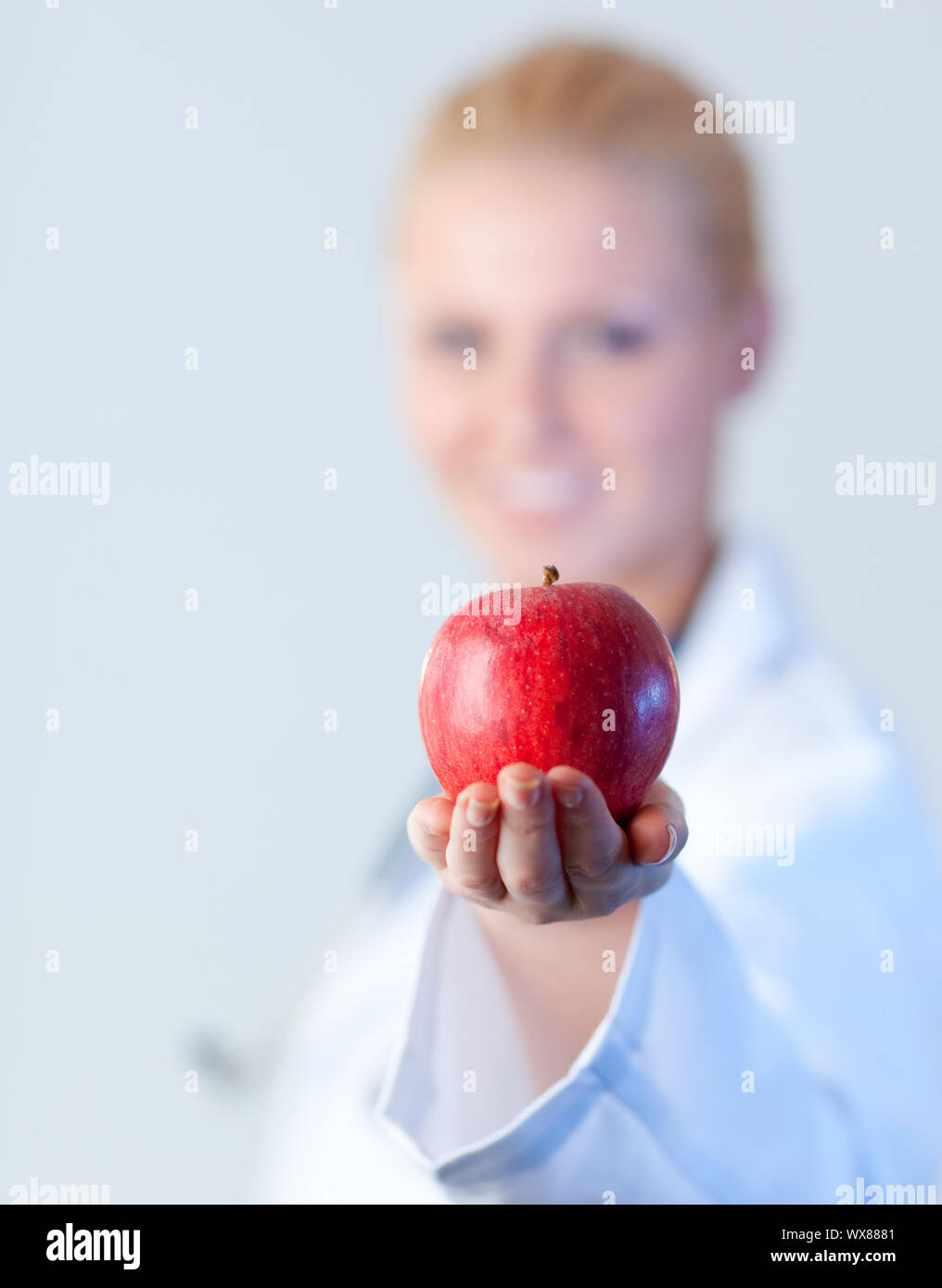 Doctor holding an apple with focus on the apple Stock Photo - Alamy