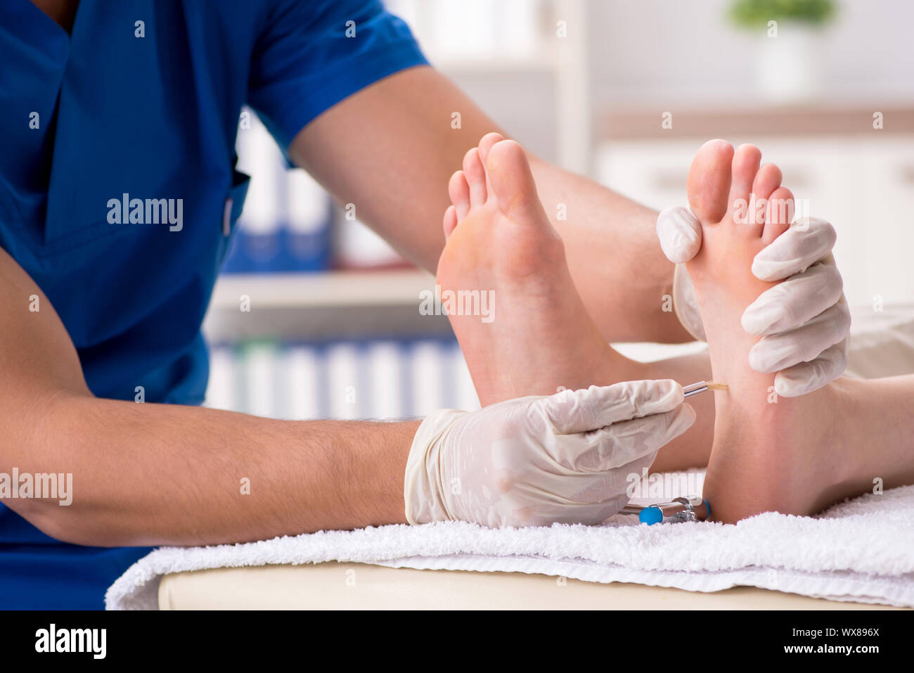 Podiatrist treating feet during procedure Stock Photo - Alamy