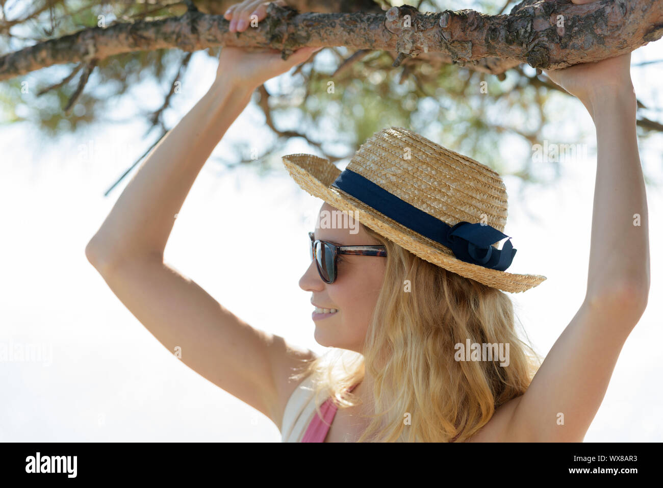 woman holding tree branch while looking at distance Stock Photo - Alamy